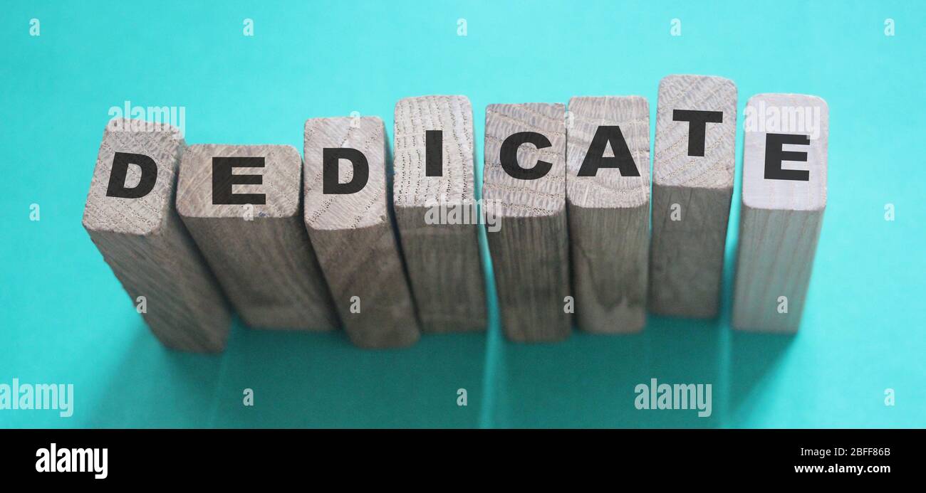 Word Dedicate on a row of wooden blocks. Devotion dedication love ...