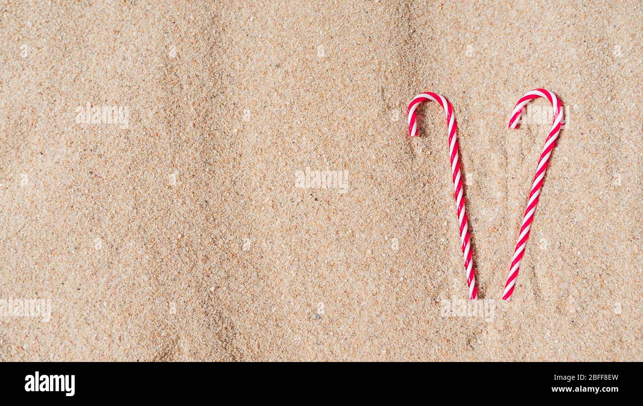 candy cane on the sandy beach. new year and xmas vacation in hot ...