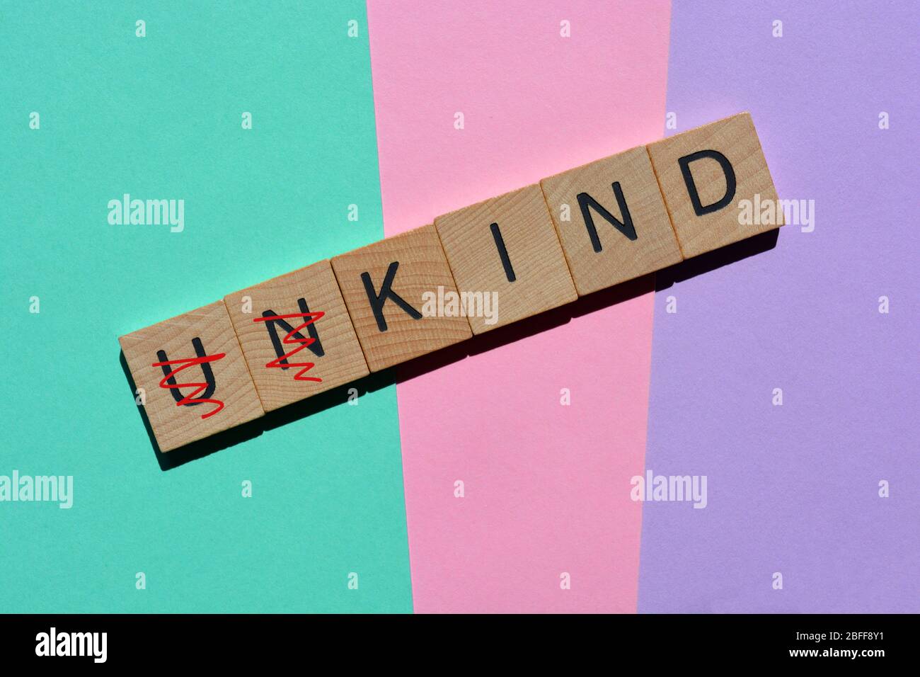 Unkind, word in 3d wood alphabet letters with un crossed out, leaving ...
