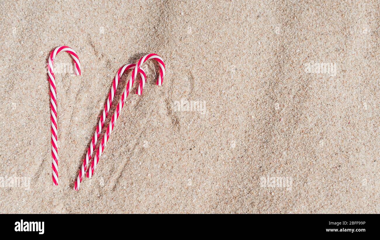 candy cane on the sandy beach. new year and xmas vacation in hot ...