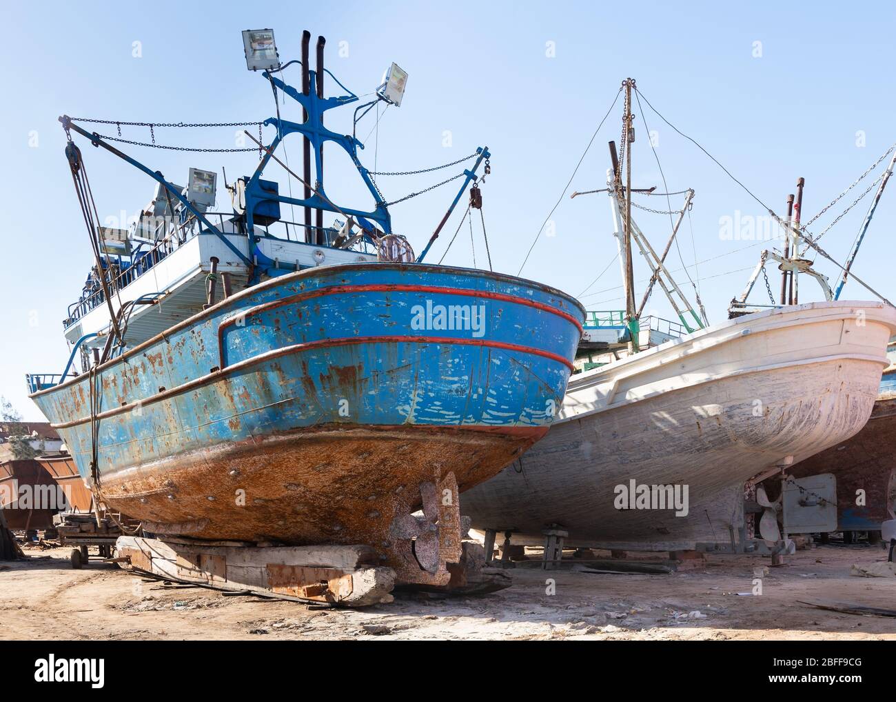 Old rusty vessels under repairing located on grungy dry dock in ...