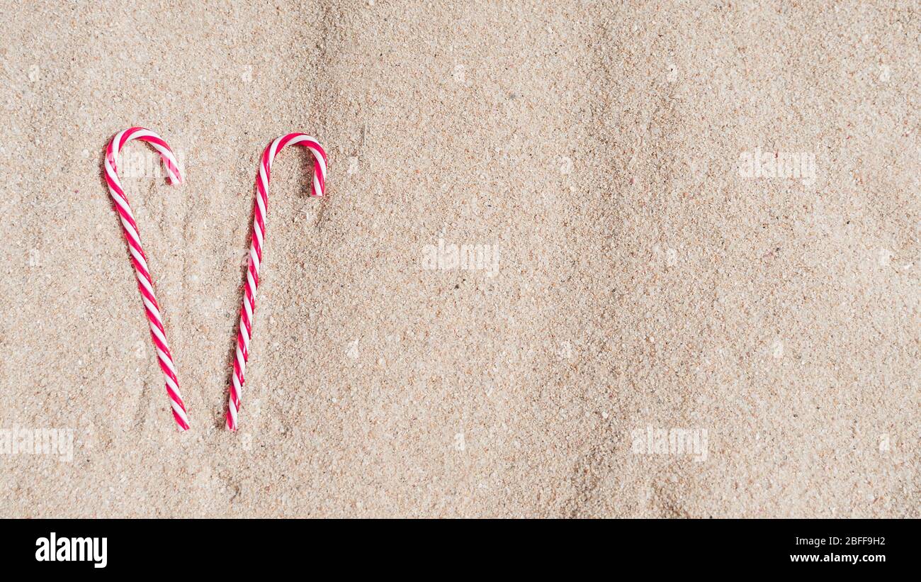 candy cane on the sandy beach. new year and xmas vacation in hot ...