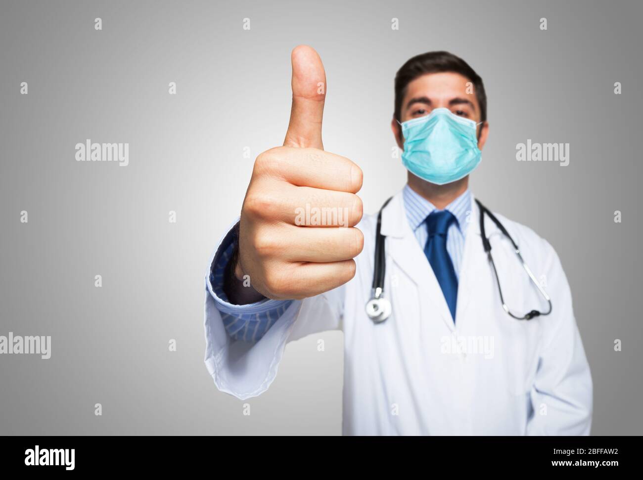 Portrait of a friendly doctor smiling giving thumbs up Stock Photo - Alamy