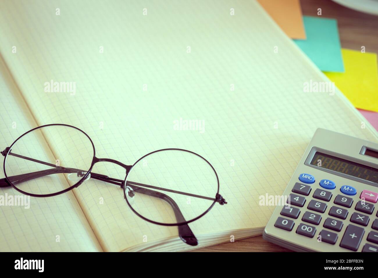 An open notebook with space for text. Old-fashioned glasses, calculator ...