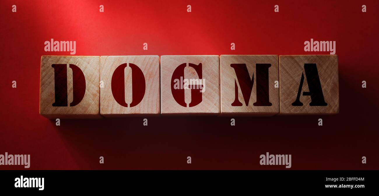 DOGMA word made with wooden letters on red background. Beliefs ...