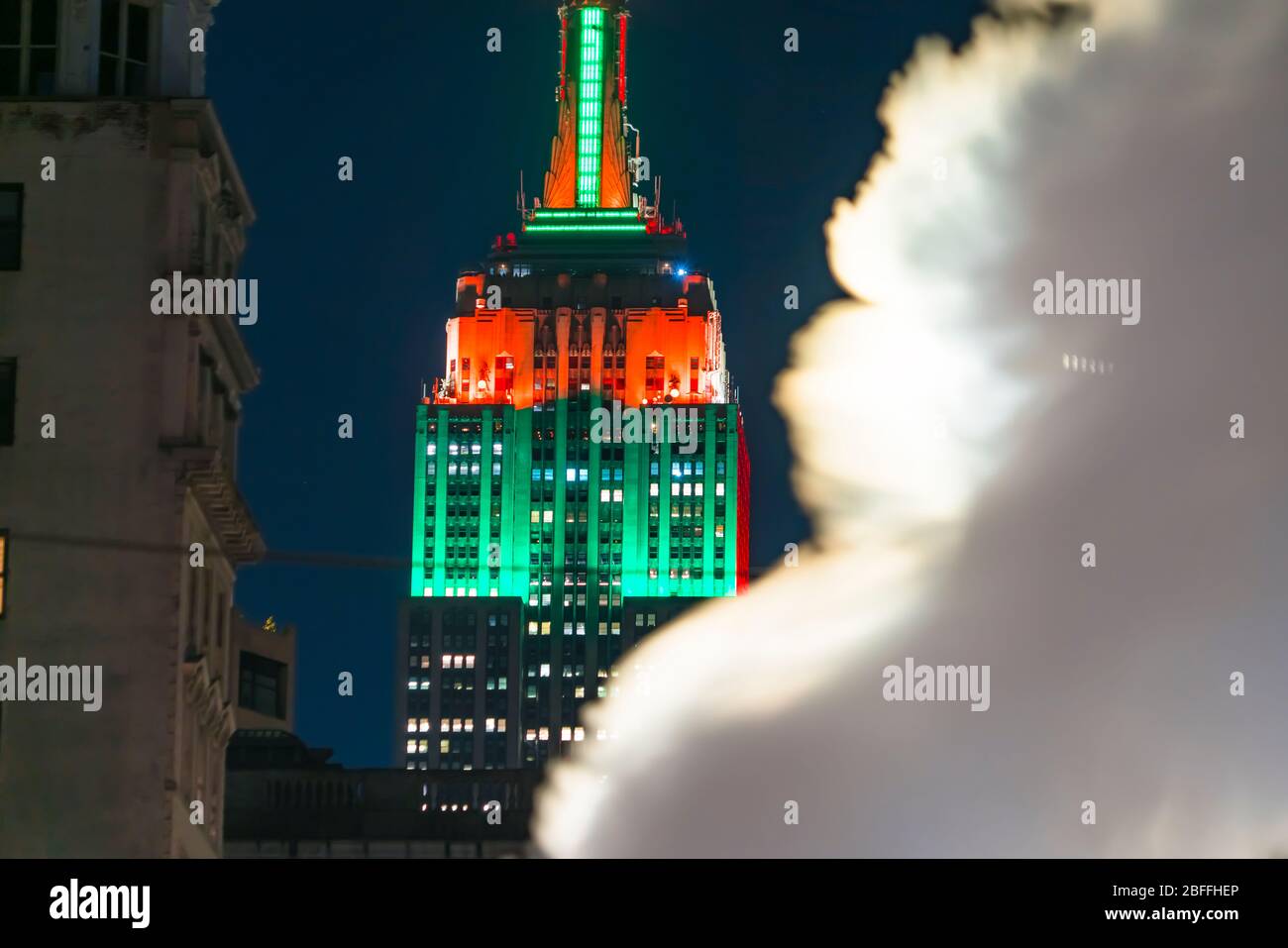 Empire State Building glows in Christmas Color behind the drifting ...