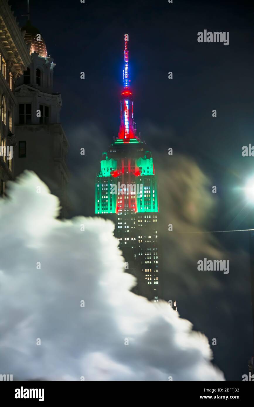 Empire State Building glows in Christmas Color behind the drifting ...