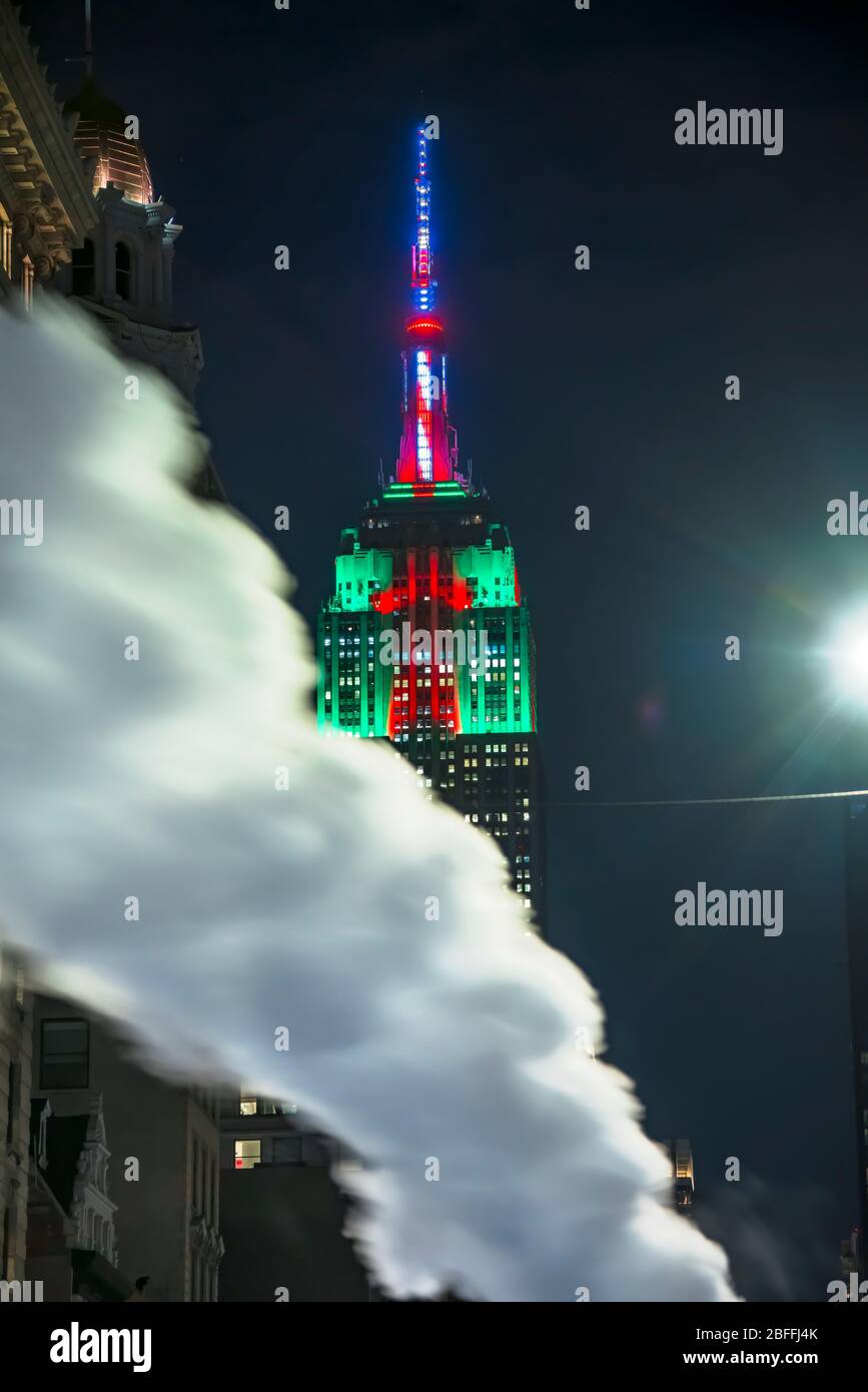 Empire State Building glows in Christmas Color behind the drifting ...