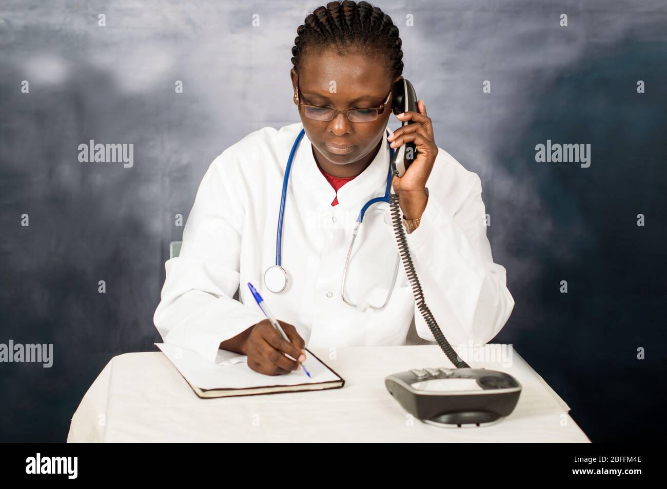 Female doctor calling by phone at the office and giving a prescription ...