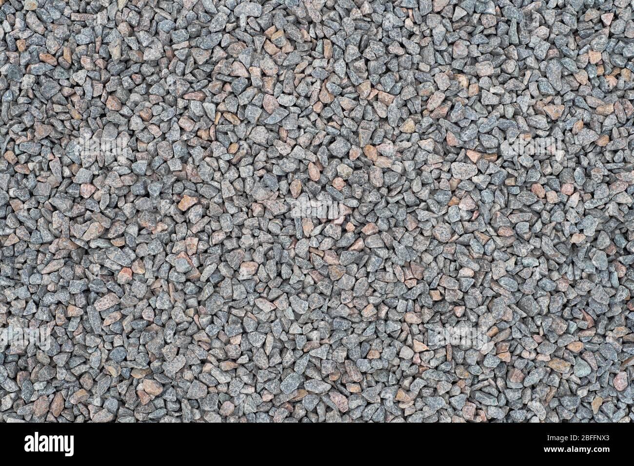 Crushed rock is scattered on the ground, surface. Close-up of crushed f ...