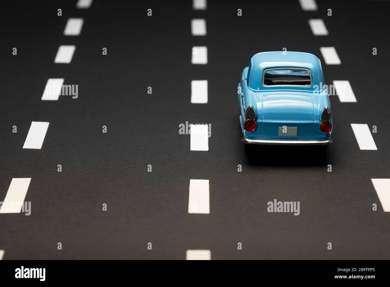 Rear view of a blue toy car on an asphalt road Stock Photo - Alamy
