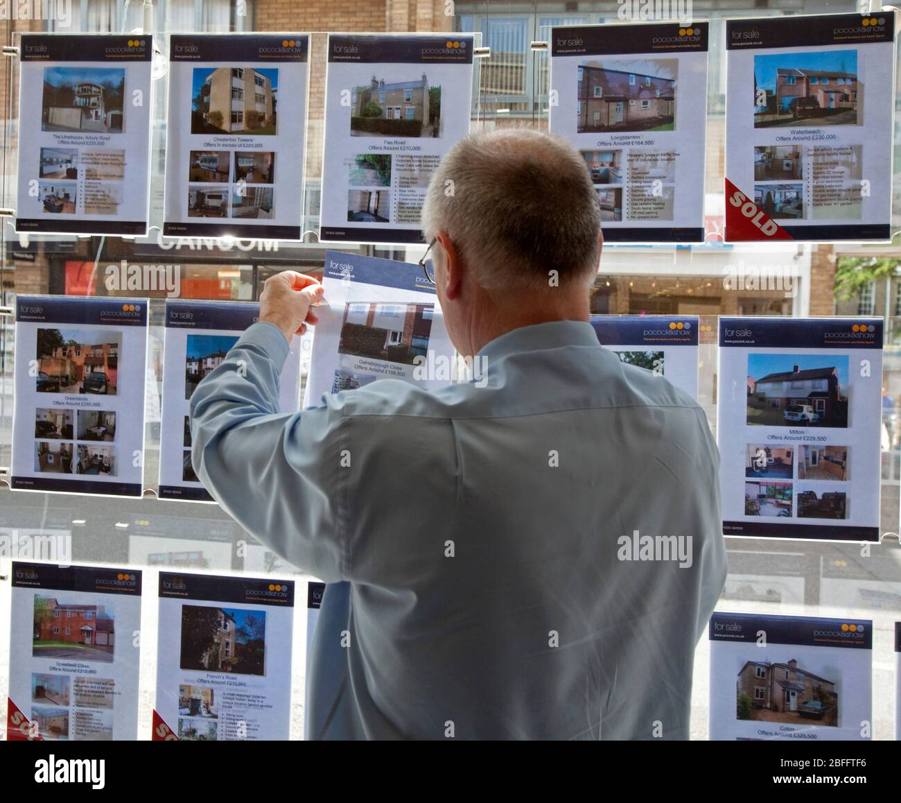 An Estate Agent changes a window display Stock Photo - Alamy