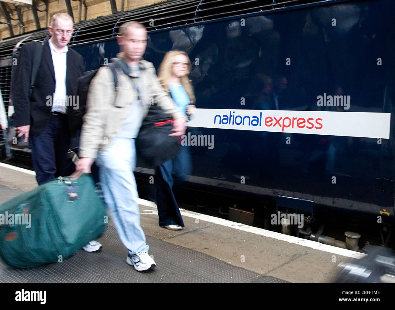 People pass by a National Express train at Kings Cross station, London ...