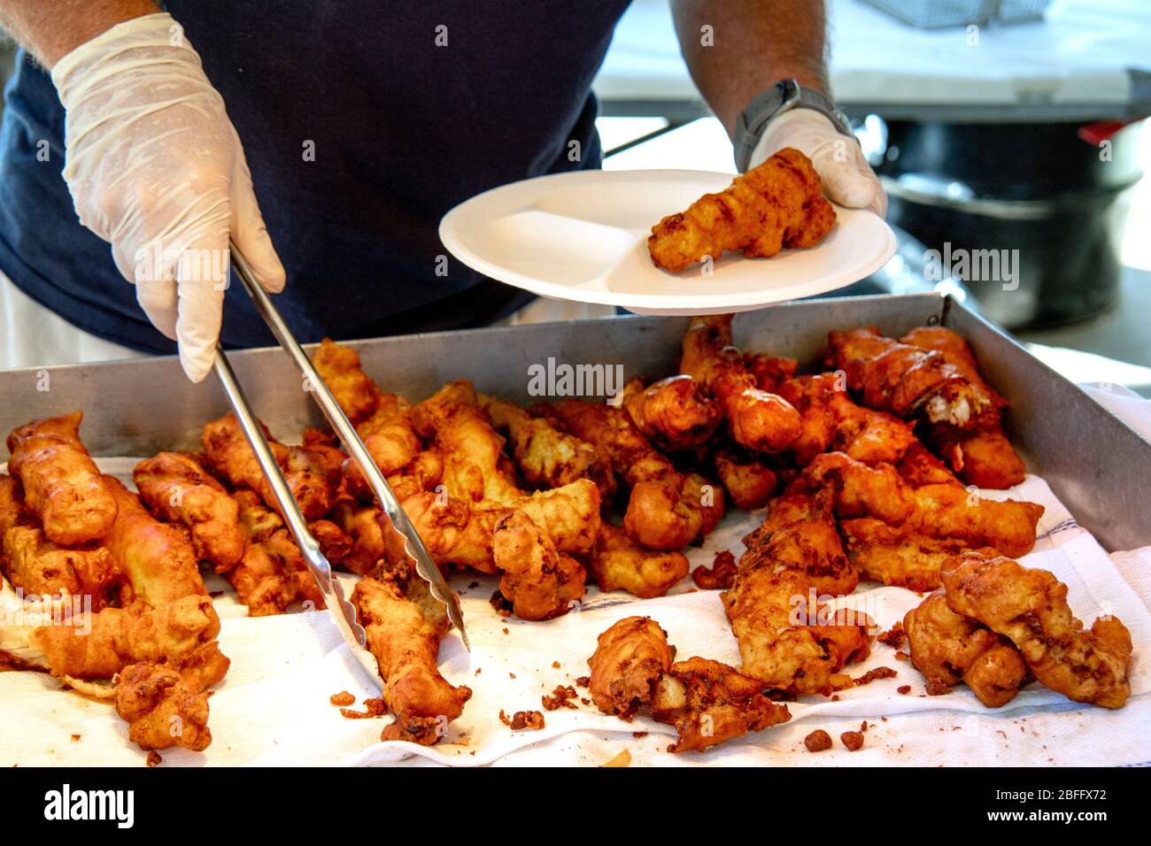 Deep fried Alaskan cod are ready to serve at an outdoor festival in a ...