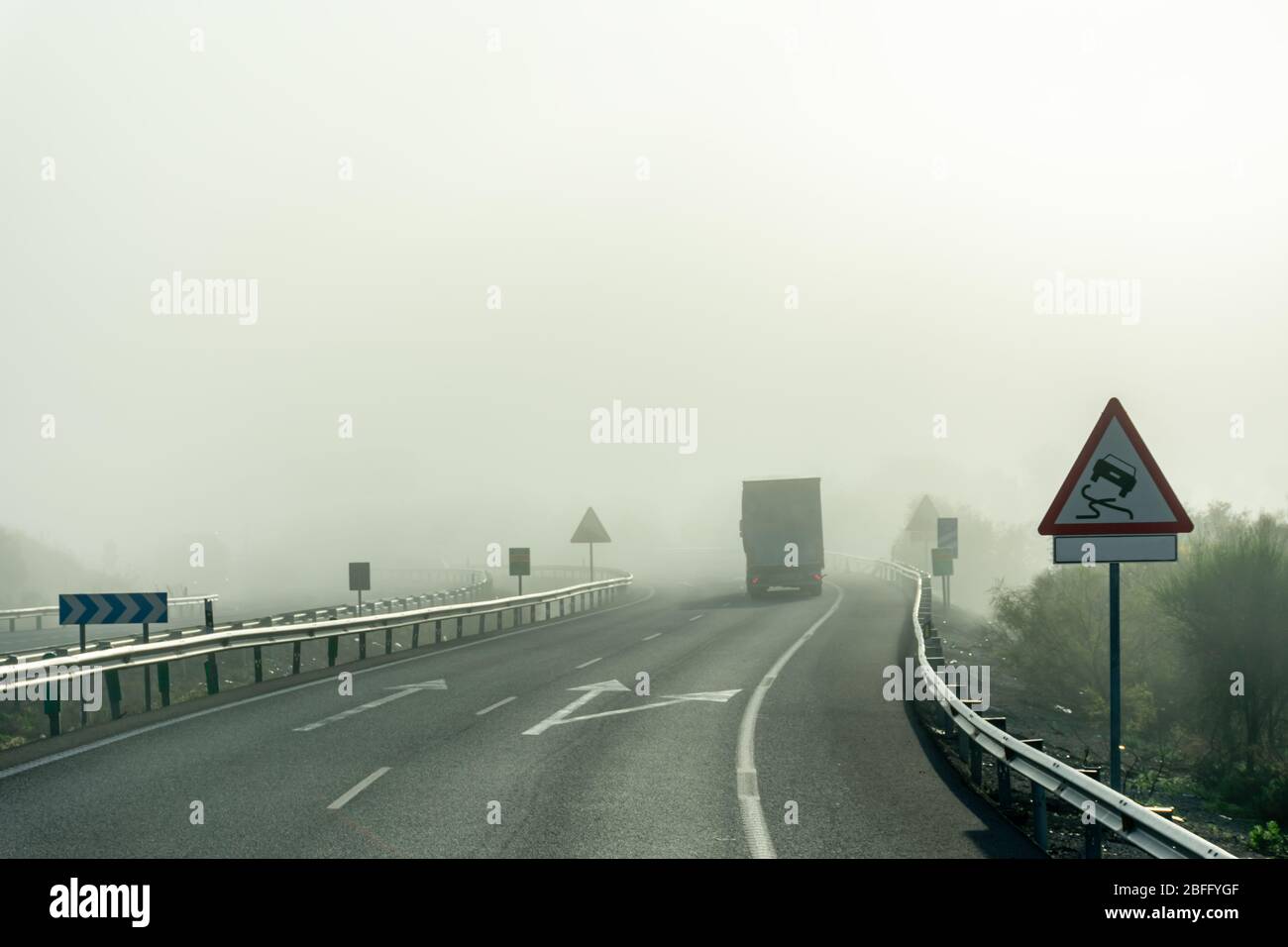 Truck driving on the highway getting lost in the fog Stock Photo - Alamy