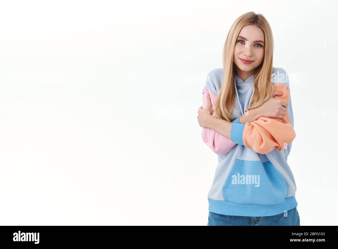 Portrait of tender, feminine blond caucasian girl in hoodie, cuddling ...