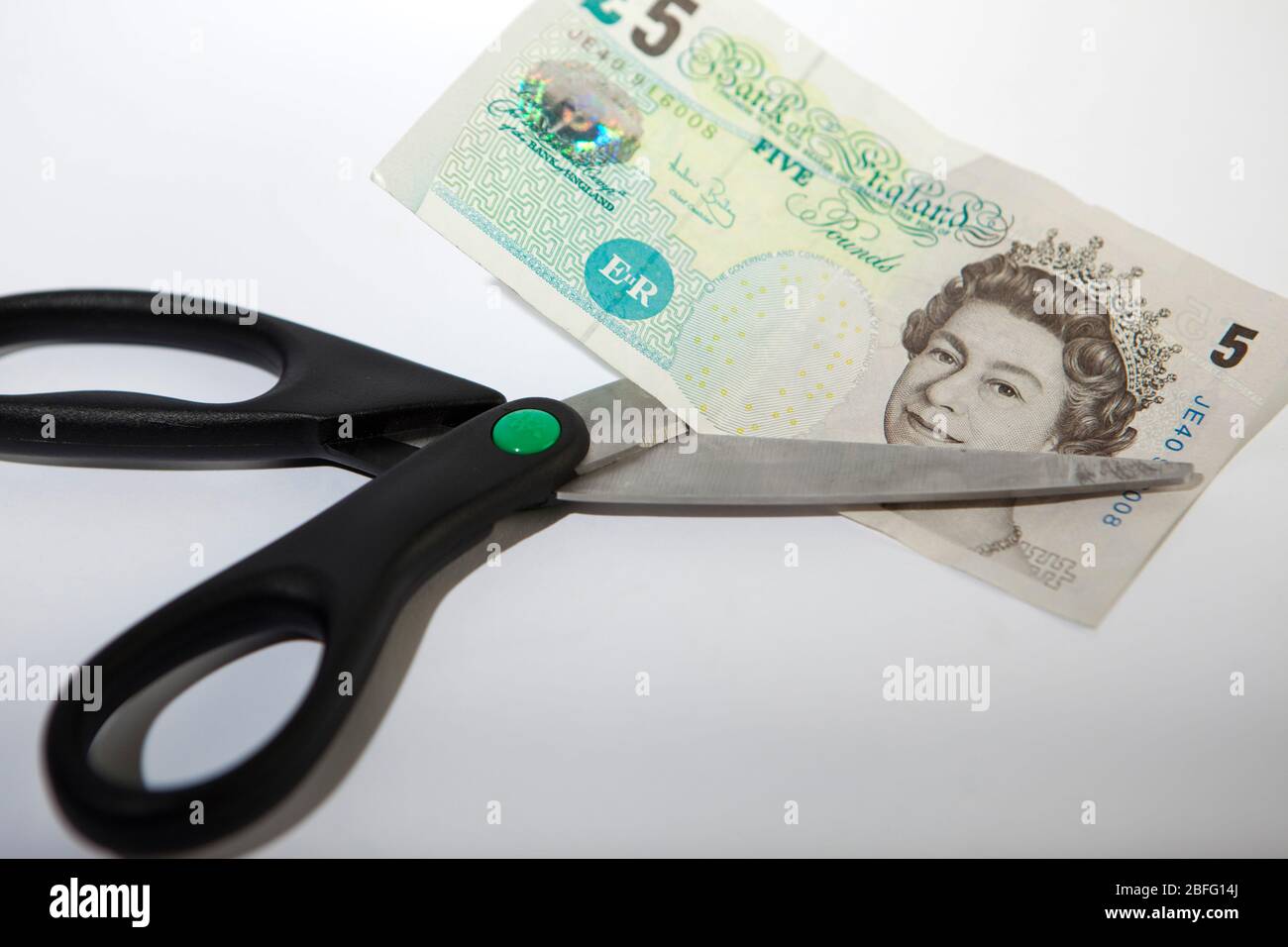 Illustrative image of a £5 note being cut in half Stock Photo - Alamy