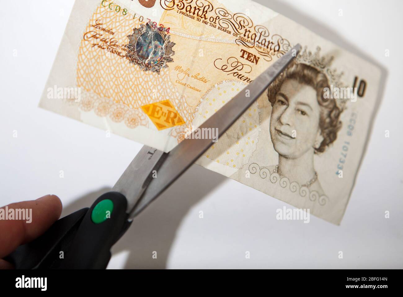 Illustrative image of a £10 note being cut in half Stock Photo - Alamy