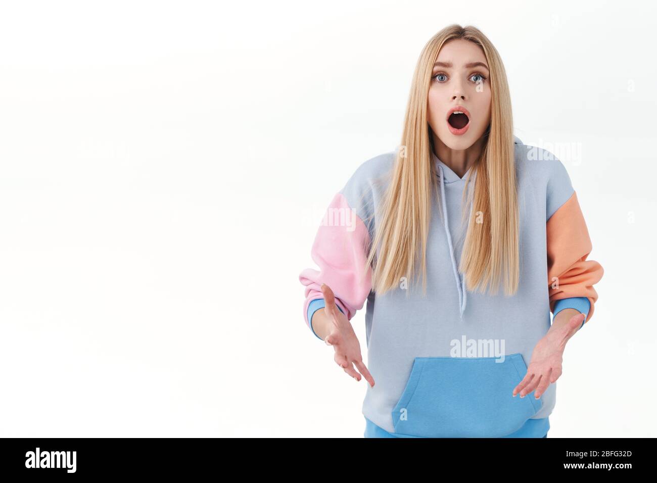 Startled young woman raising hands and gasping worried, catching ...