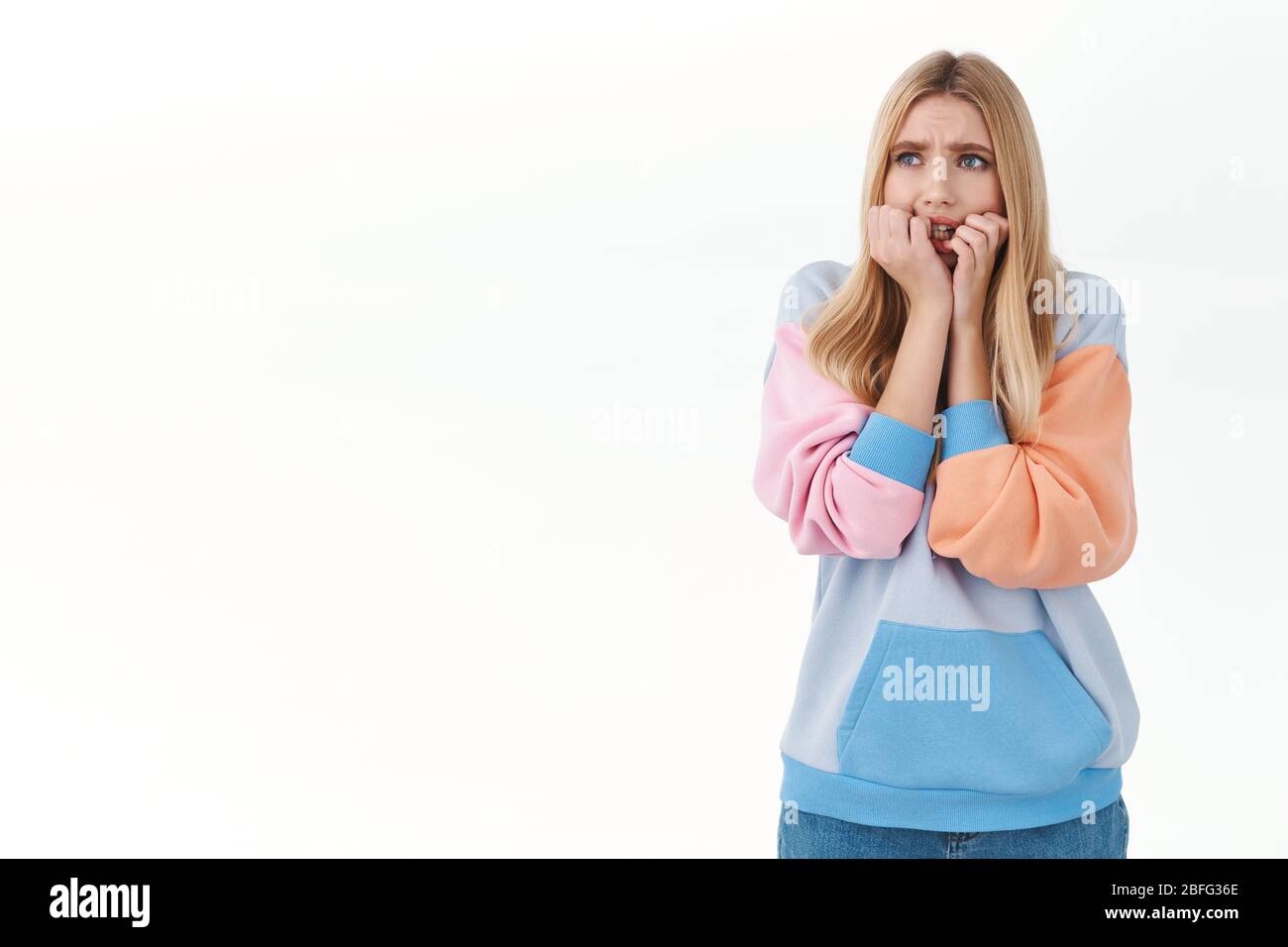 Scared blond insecure girl feel unsafe, trembling fear, biting nails ...