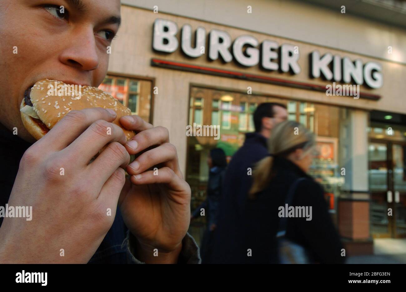 A Burger King customer eating his burger Stock Photo - Alamy