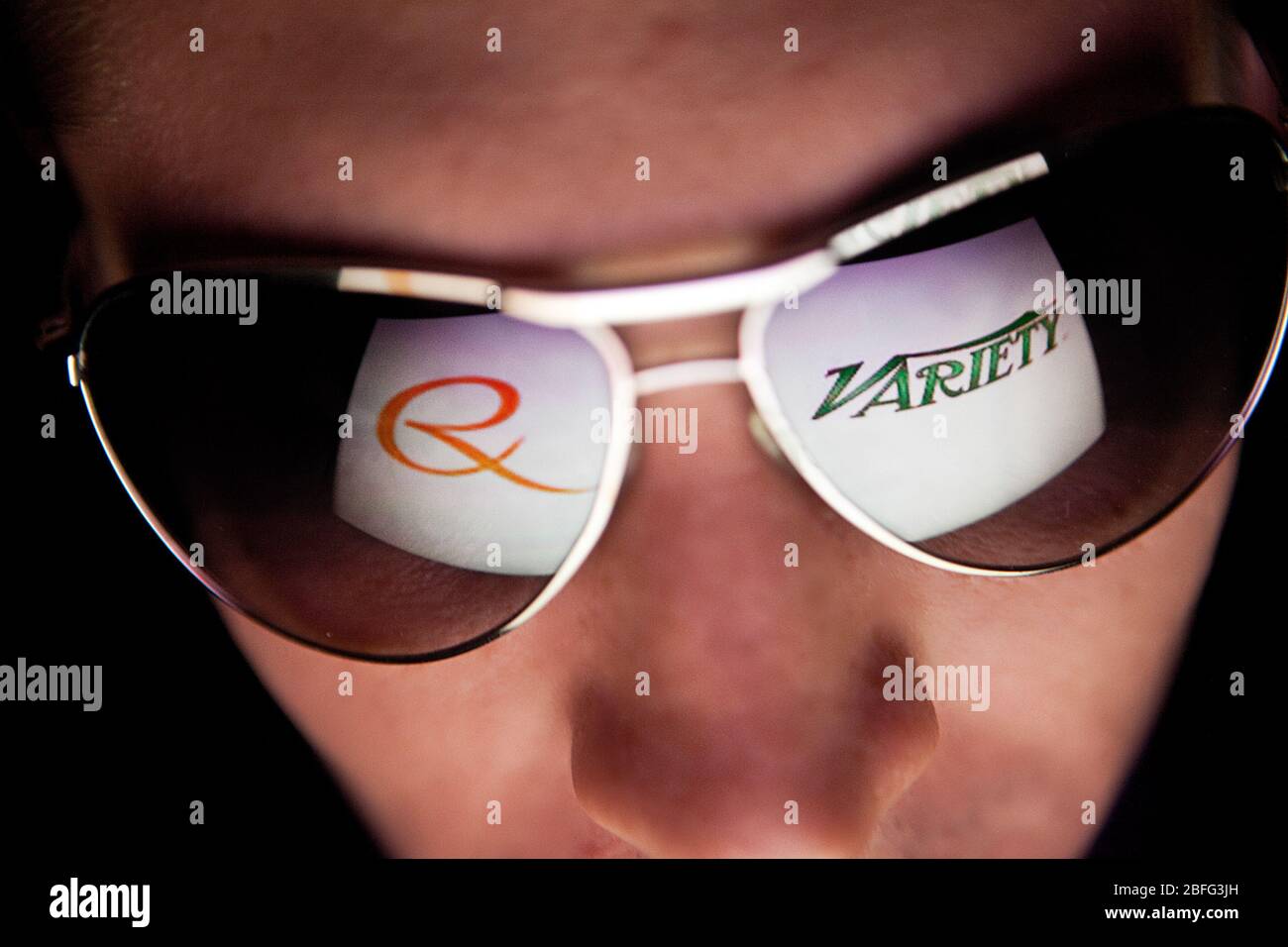 Reflected image of someone looking at a computer screen showing the ...