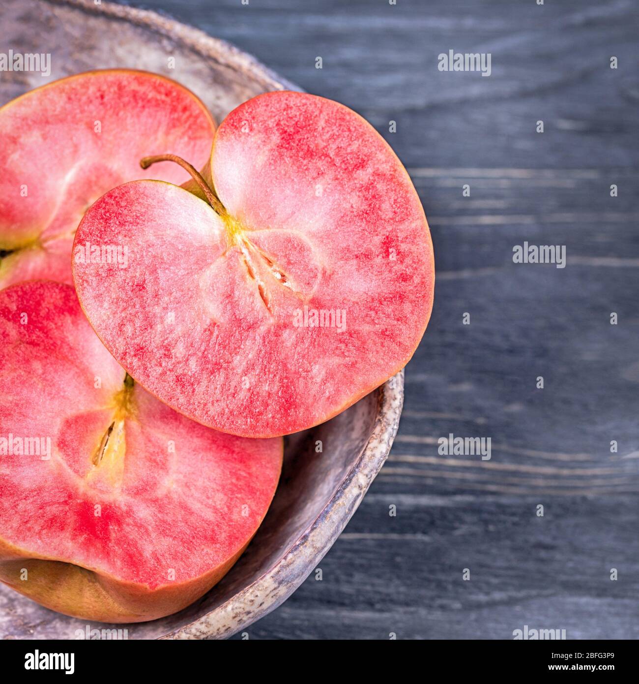 Pink and red fleshed apples on a dark background. Apples with pink ...