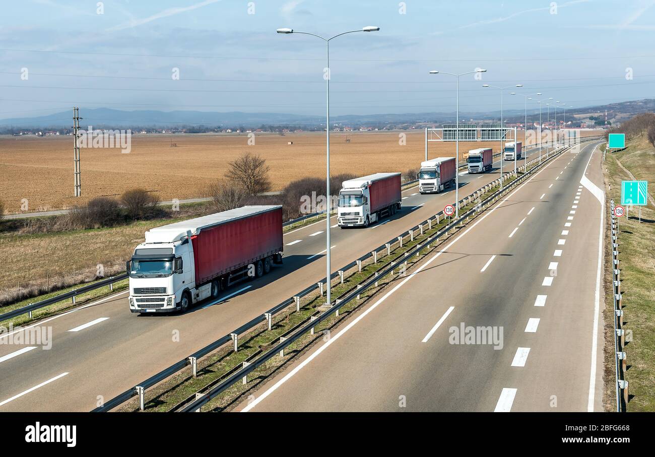 Convoy of transportation trucks in line as a caravan or convoy on a ... Convoy of transportation trucks in line as a caravan or convoy on a ...