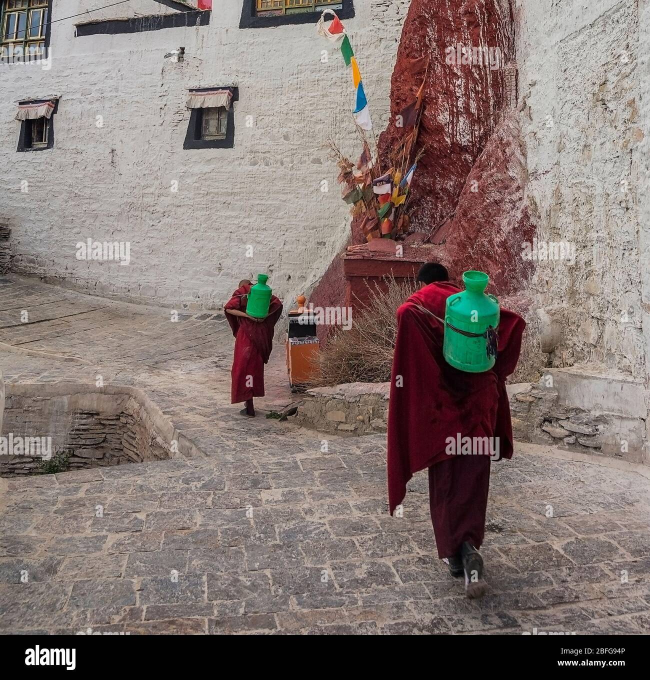 Monks carry water uphill for the use of the monastery, Shelgar, Tibet ...