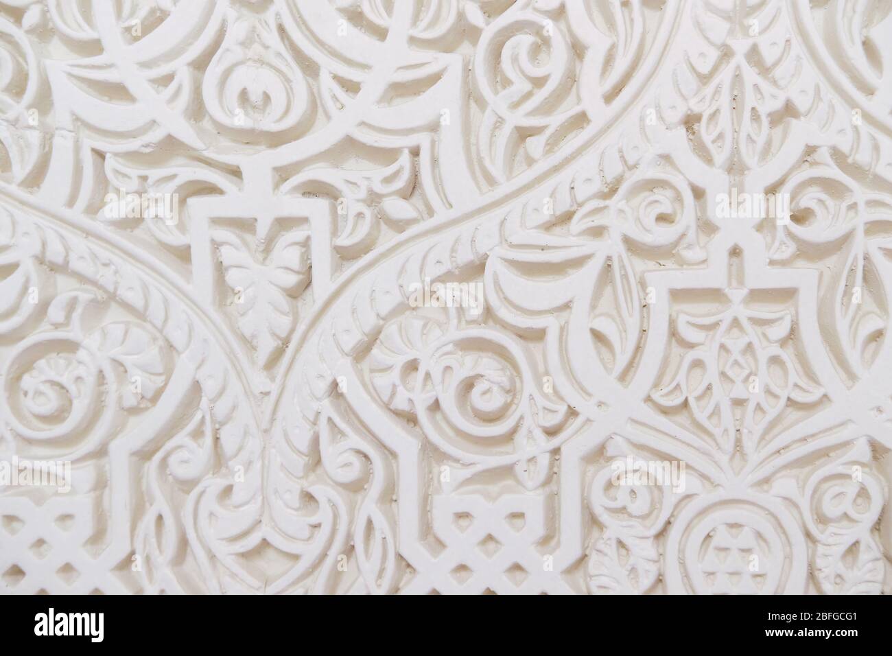 Handmade traditional arabic ornament carved on the cement white wall. Craft and art Middle East ...
