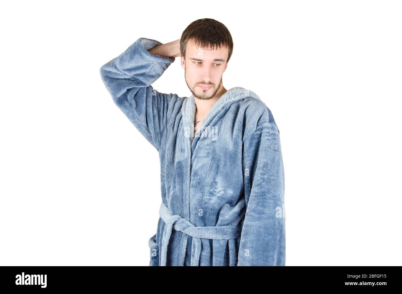 Portrait of young caucasian bearded man in blue bathrobe shows clueless ...