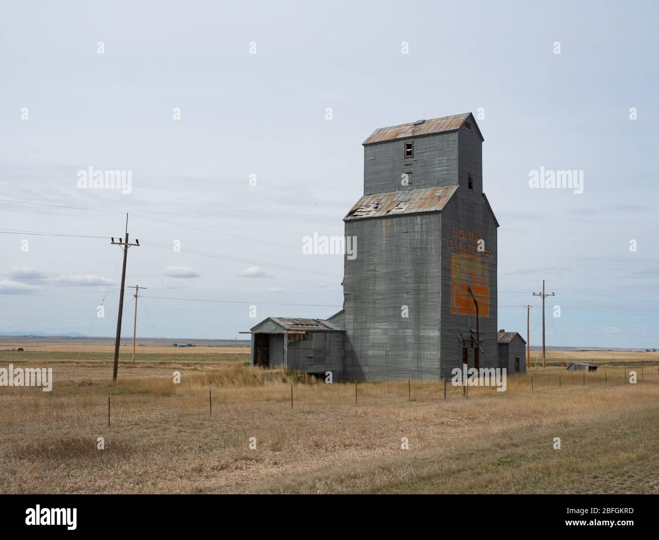 Steel-sided grain elevator with sign painted on the side. Prairie and ...