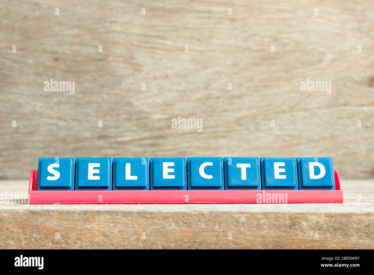 Tile letter on red rack in word selected on wood background Stock Photo ...