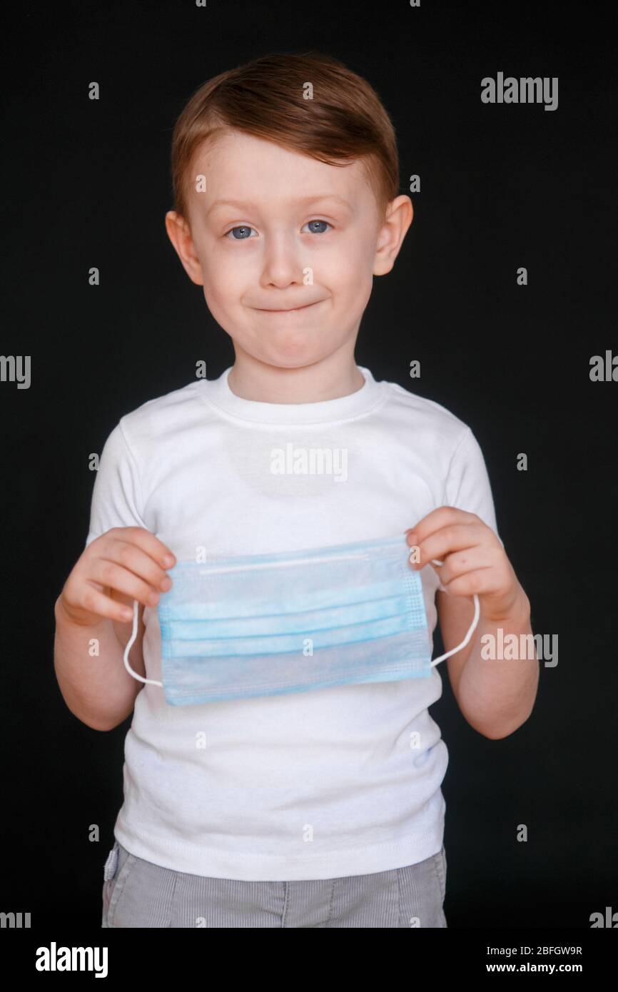 A little boy is holding a medical mask. Baby wears face masks covid-19 ...