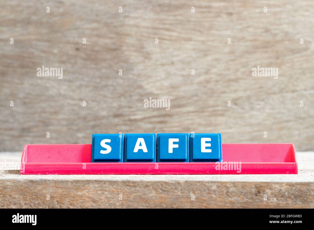 Tile letter on red rack in word safe on wood background Stock Photo - Alamy