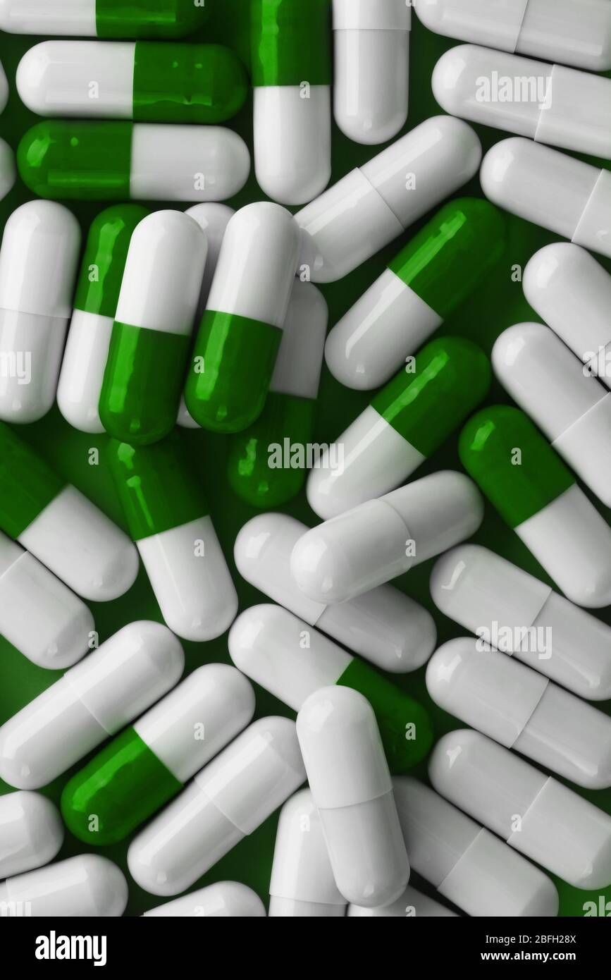 Green and white capsules close up. Medicine pills capsules background ...