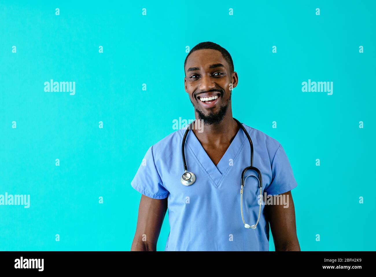 Portrait of a happy male doctor or nurse wearing blue scrubs uniform ...