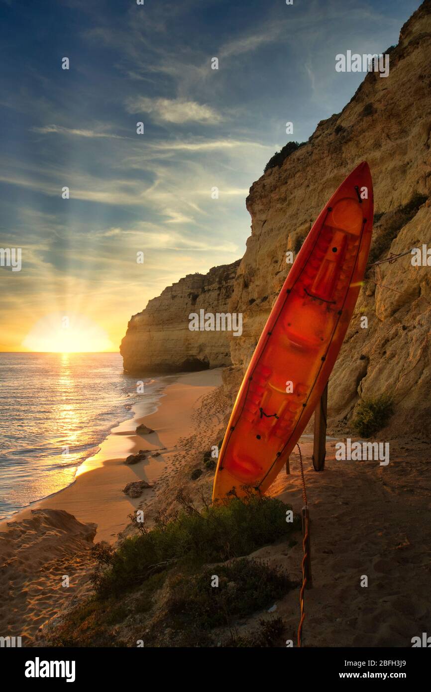 Orange kayak on a beach in the Algarve, Portugal at sunset Stock Photo ...