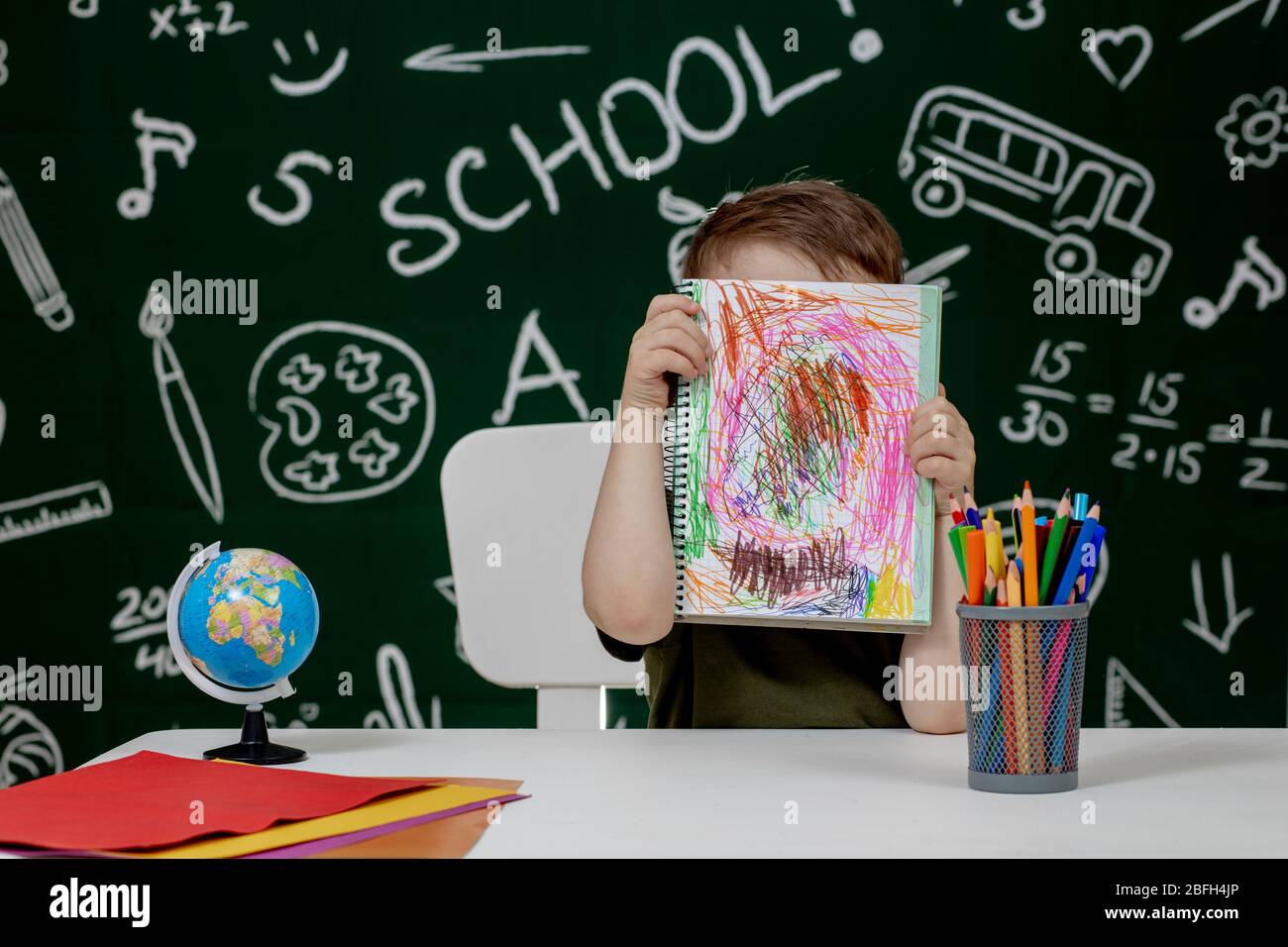 Cute child boy doing homework. Clever kid drawing at desk. Schoolboy ...