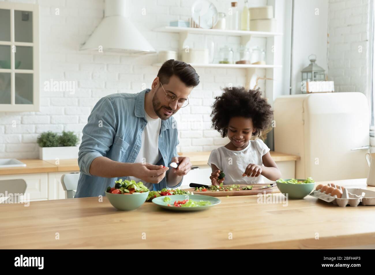 Caucasian father and biracial daughter cook together Stock Photo - Alamy