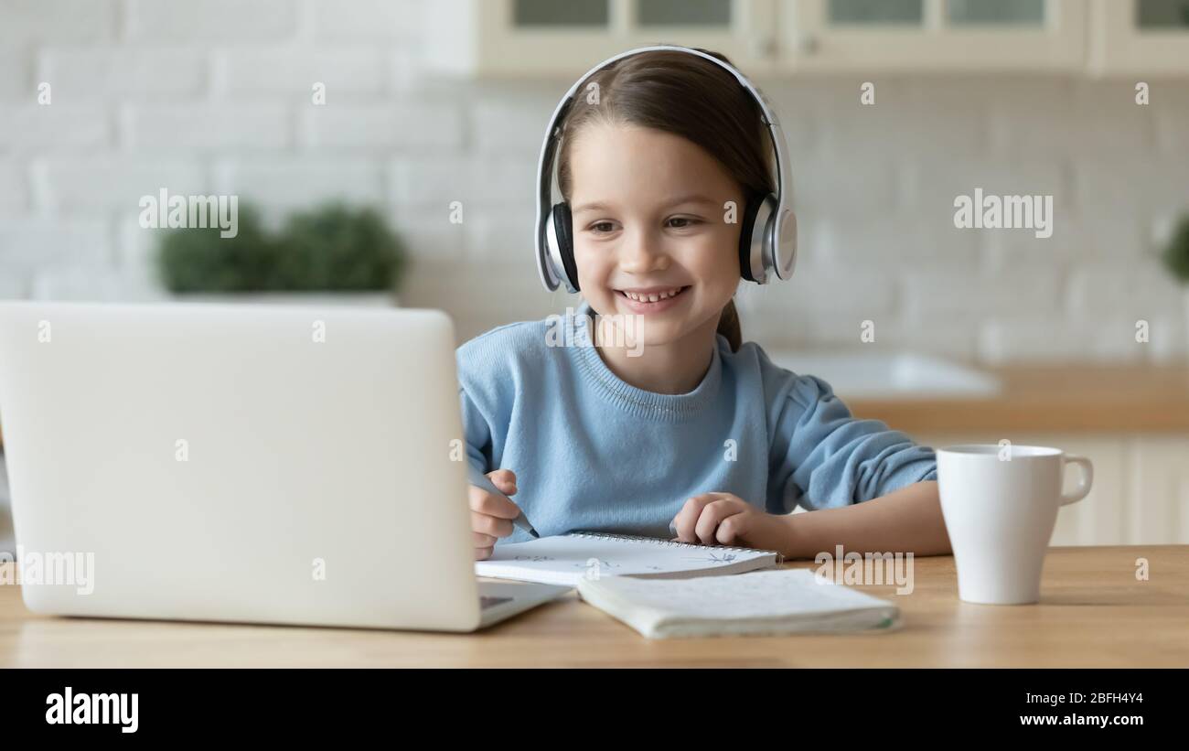 Smiling little girl study online using laptop Stock Photo - Alamy