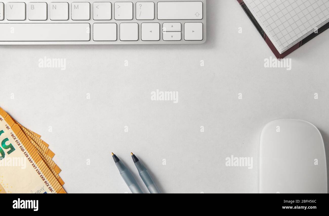 Computer keyboard, computer mouse, ballpoint pens, notebook and money ...