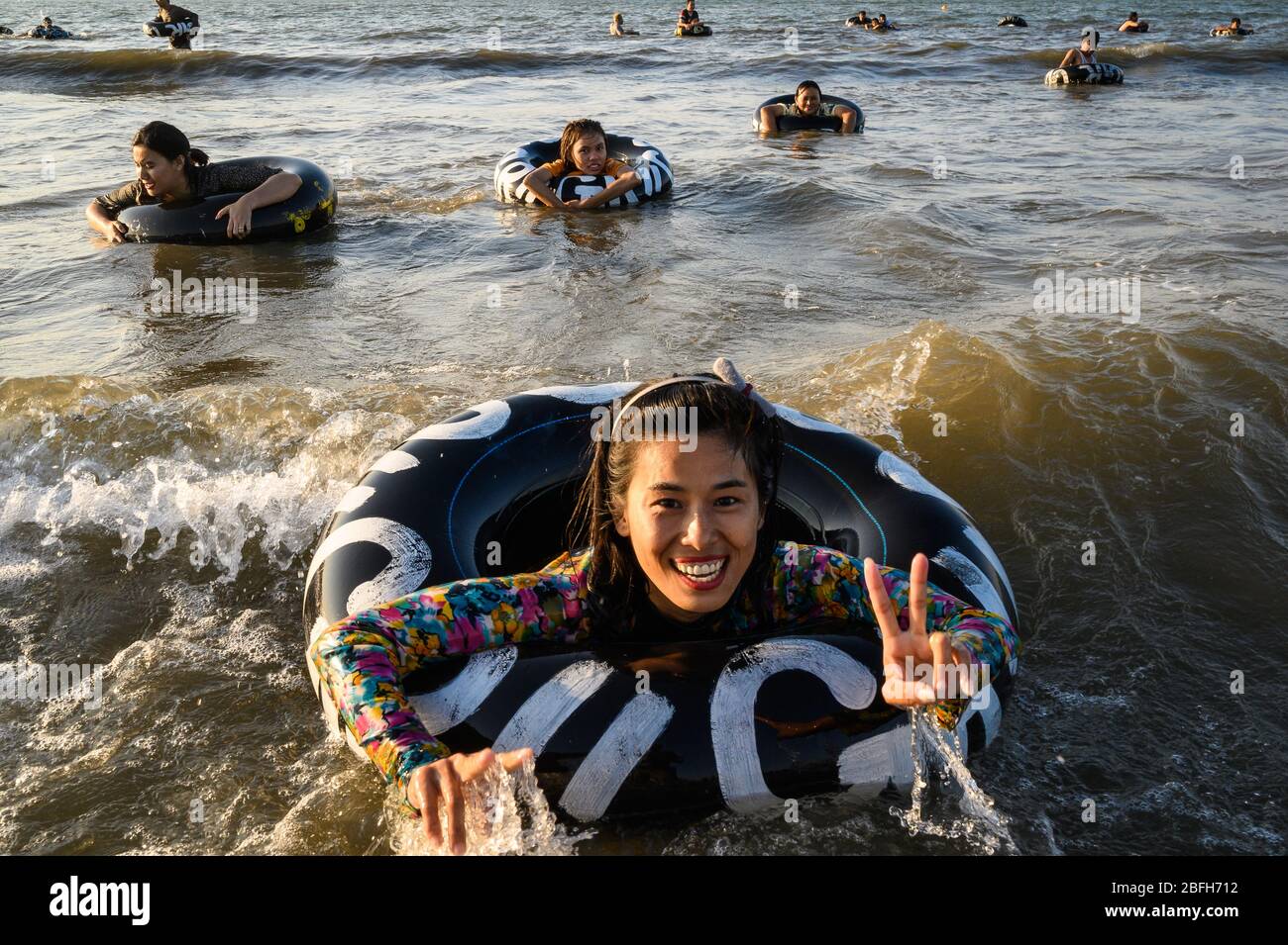 Burmese women floating on inner tubes, Chaung Tha, Myanmar Stock Photo ...