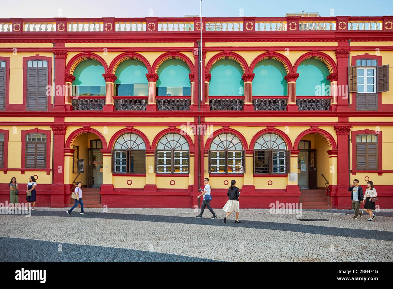 People walking by the colourful building of the Macao Central Library ...