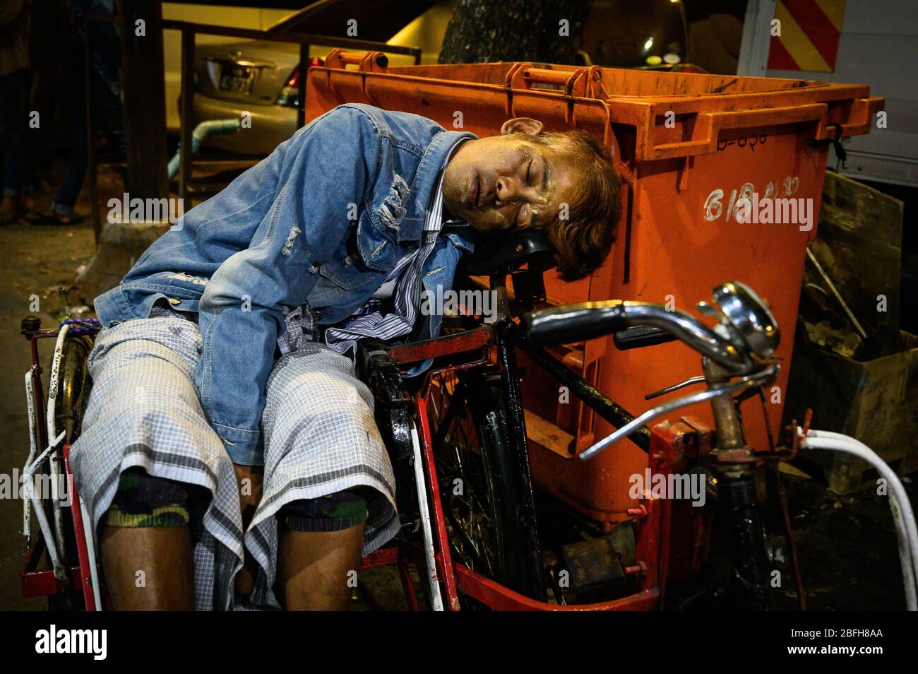 Cycle trishaw driver sleeping on a bicycle seat, Yangon, Myanmar Stock ...