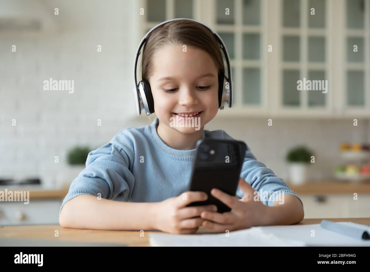 Little girl watch video on smartphone at home Stock Photo - Alamy
