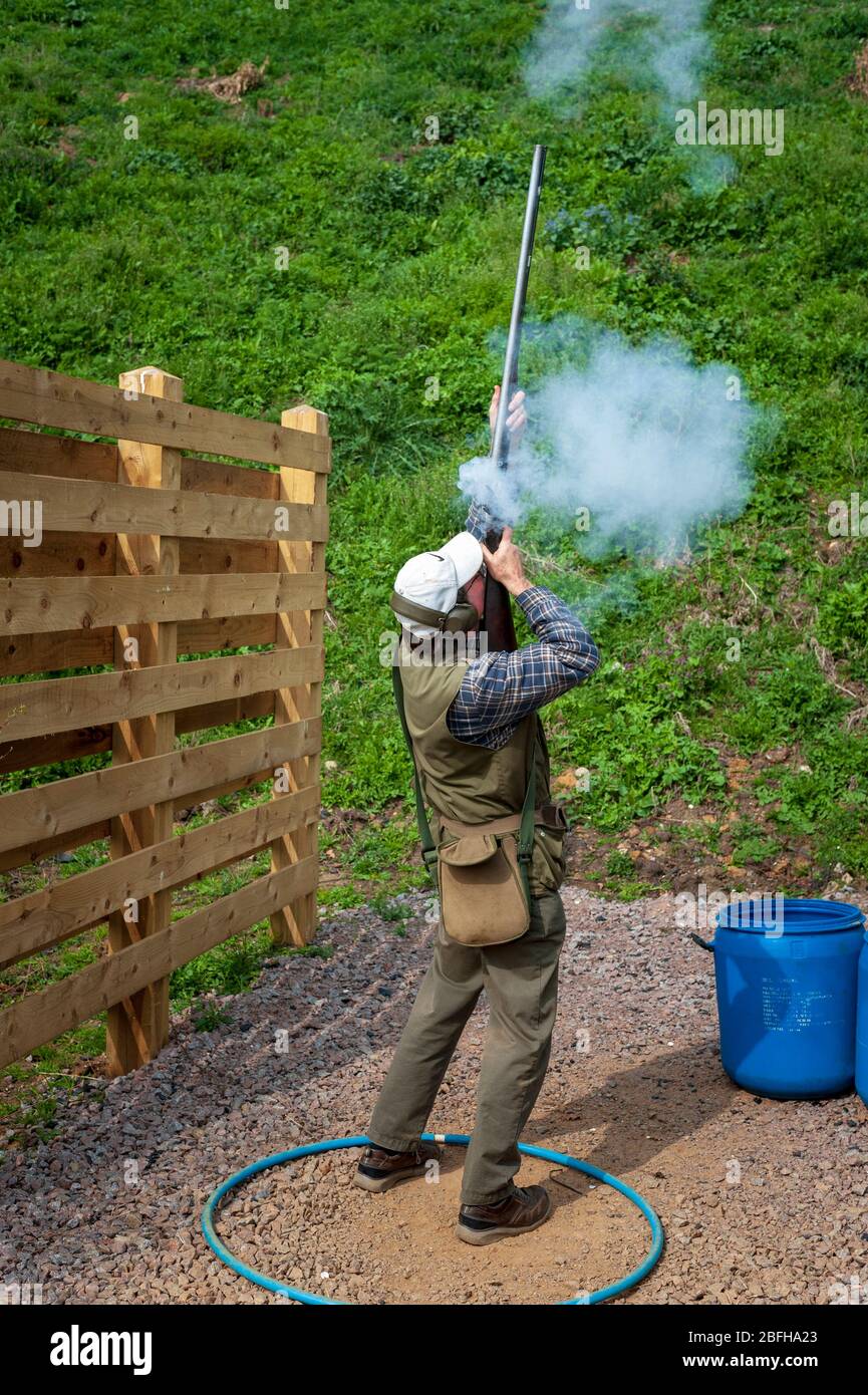 An antique flint lock gun being fired by a man during a clay pigeon ...