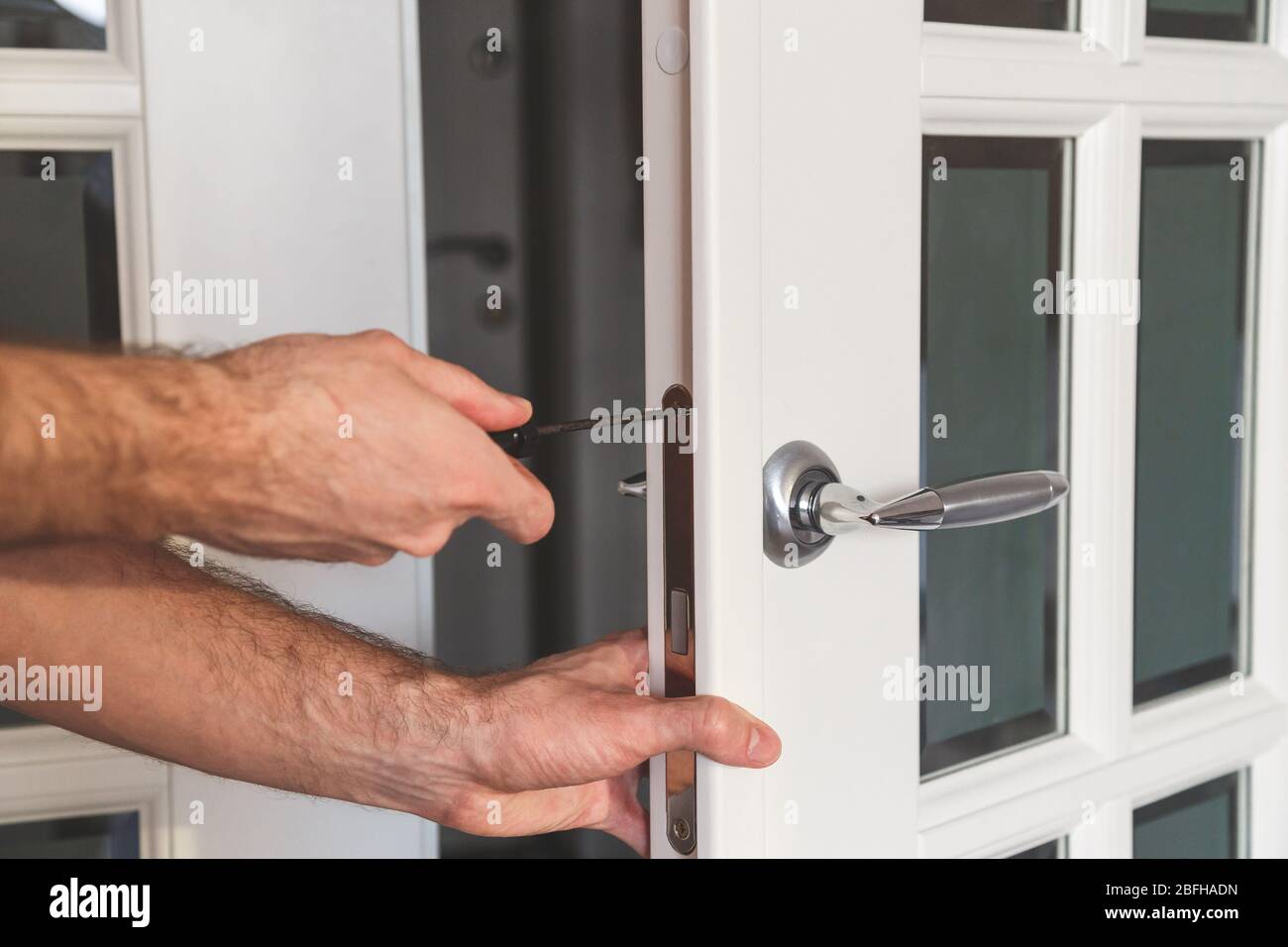 Male handyman carpenter at interior wood door lock installation Stock ...