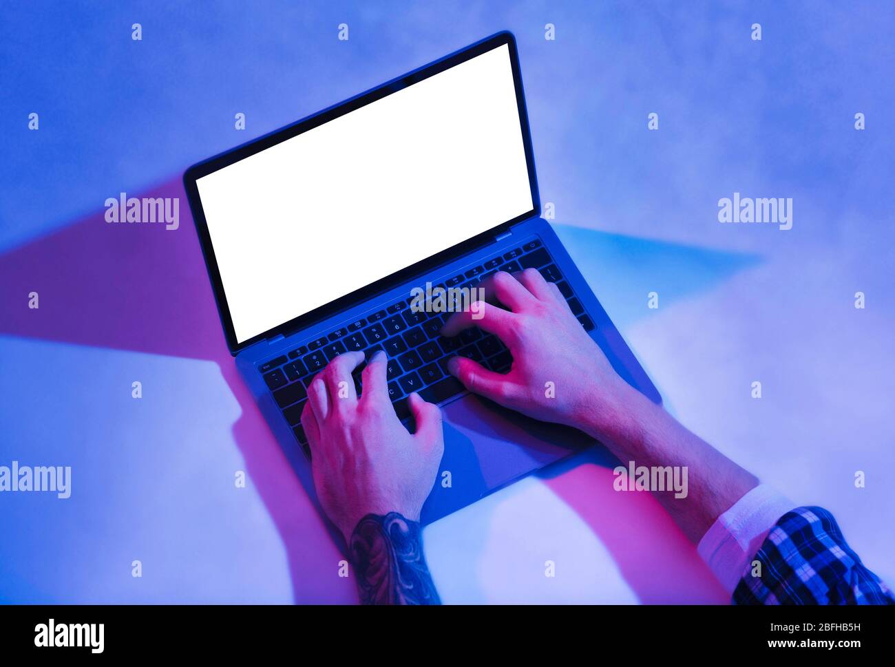 Man typing on laptop with blank screen Stock Photo - Alamy
