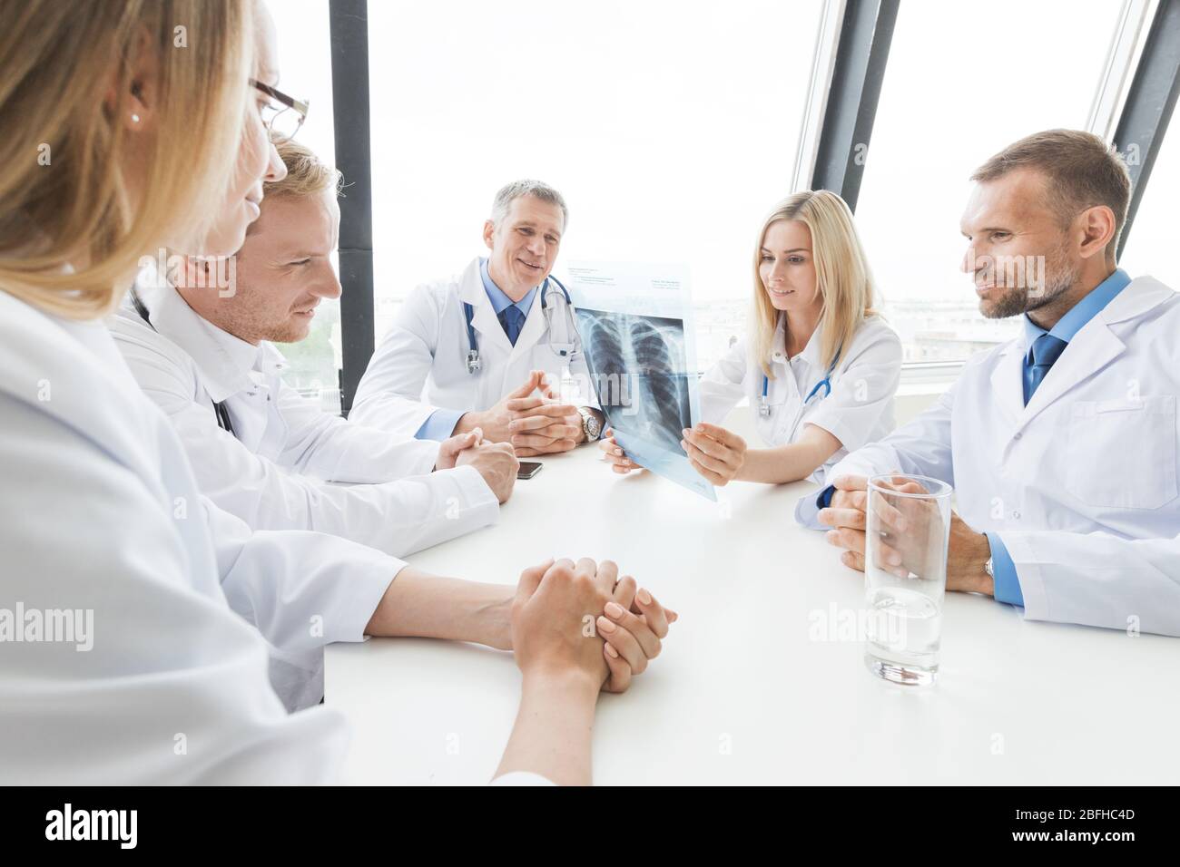 Team of experts doctors examining X-ray report on hospital office ...